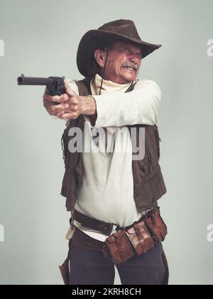 Cowboy, funny man and shooting gun in studio, weapon and pistol for ...