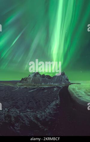 Breathtaking polar light shining over rough stony formation near icy ...