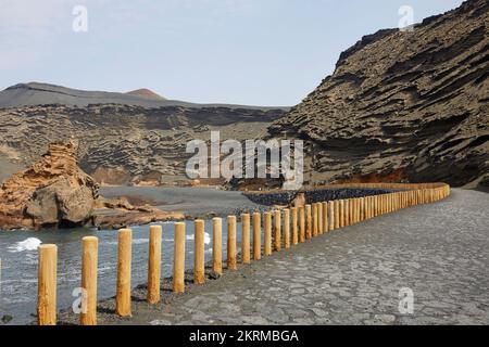 Pathway with wooden fence near rocky mountain and ocean in Green Lake ...
