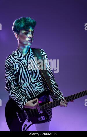 Female musician in trendy outfit playing electric guitar while standing ...