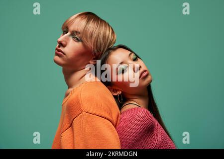 Diverse genderqueer models in colorful stylish clothes holding hands ...