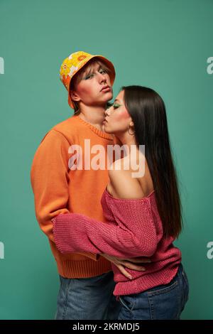 Diverse genderqueer models in colorful stylish clothes embracing each ...