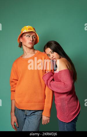 Diverse genderqueer models in colorful stylish clothes embracing each ...