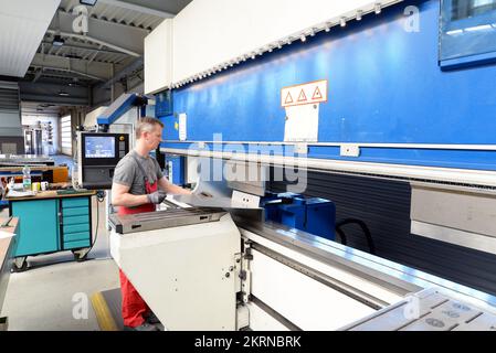 employee operates bending machine in a metalworking company - bending ...