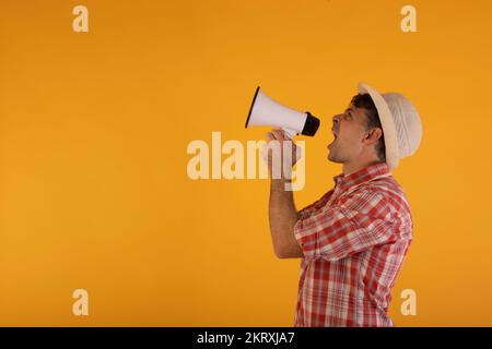 Mature man with megaphone loudspeaker sending a message to all who will ...