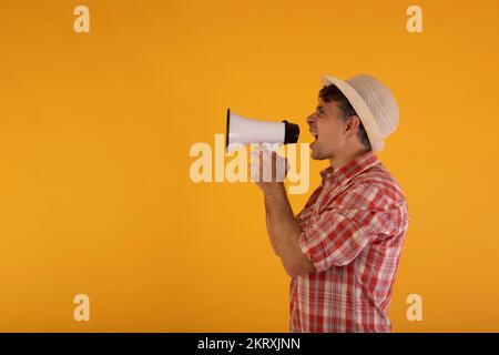 Mature man with megaphone loudspeaker sending a message to all who will ...