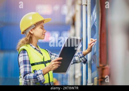 Engineer wears PPE checking container storage with cargo container ...