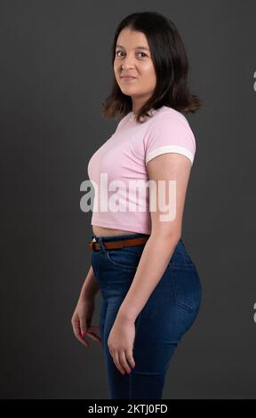 Plus size hispanic woman standing over red background smiling confident ...