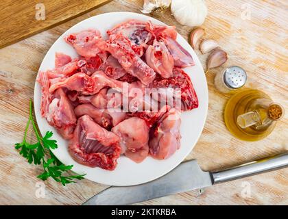 Chopped rabbit with garlic and spices on white plate with knife Stock ...