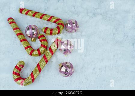 Gold and red candy canes with glitter Christmas baubles on the snow ...