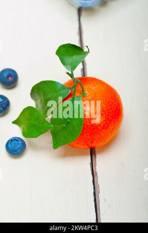tangerine and blueberry on white rustic wood table Stock Photo - Alamy