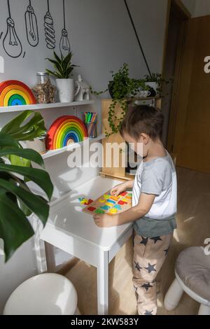 Boy kid assembling flat letters wooden puzzle block cell playing ...