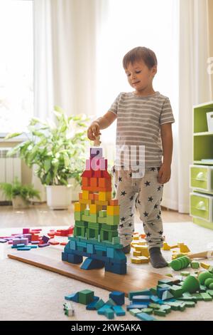Confident male kid building fortress tower architecture and forest with ...