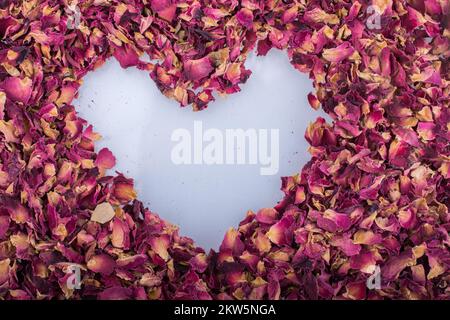 Dry petals form a heart shape on a white background Stock Photo - Alamy