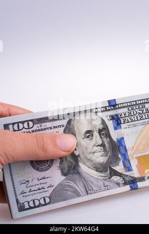 Hand holding American dollar banknotes isolated on wooden background ...