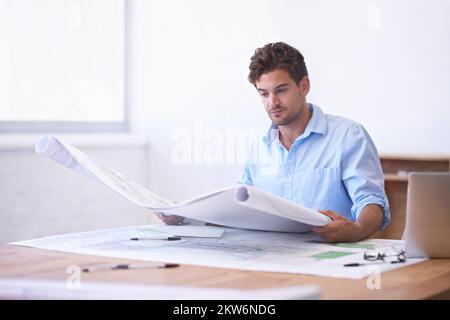 Designing the perfect building. an attractive male architect working in ...