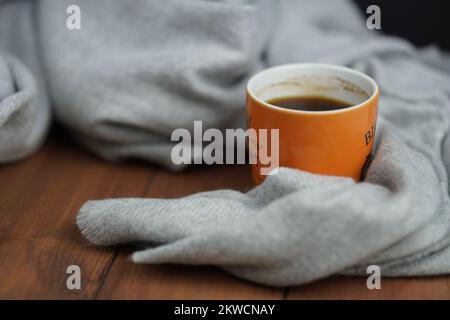 orange Cup withf hot coffee Warm grey scarf a on wooden table. Good ...
