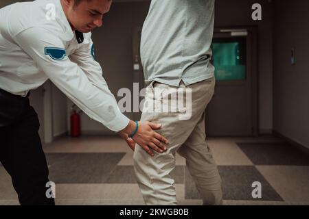 Security guard making body searching procedure with a metal detector on ...