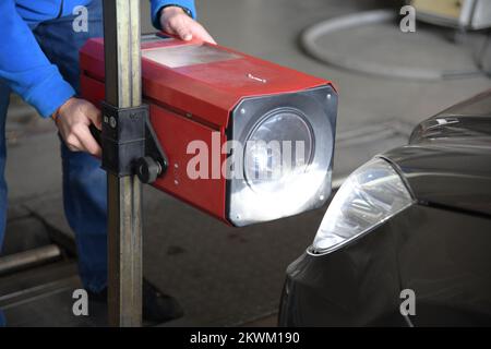 Sofia, Bulgaria - Nov 7 2022: Worker checks the headlights of a car's ...