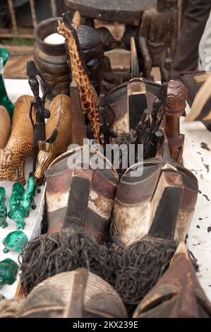 Traditional masks and other wooden souvenirs, market stall, Lubumbashi ...