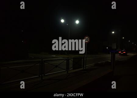 Road next to a crossing at night with cars passing by Stock Photo - Alamy