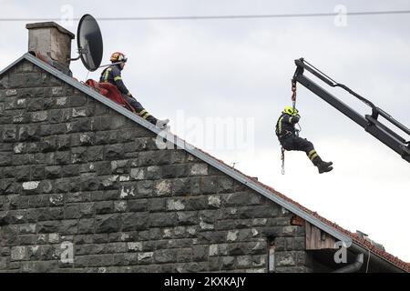 Firefighters repairing the damage on the roof which was damaged in ...