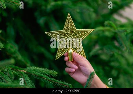 Christmas tree background Kid hand hangs decorating green Red ball toy ...