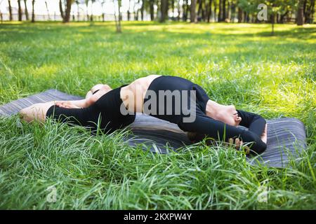 young woman doing fish pose at yoga studio Stock Photo - Alamy