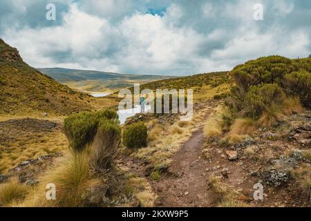 Rear view of a hiker at Lake Ellis, Chogoria Route, Mount Kenya ...