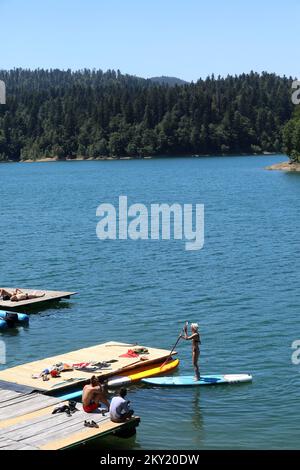 Citizens enjoy the beach Njupac by Lokvarsko Lake in Lokve, Croatia on ...