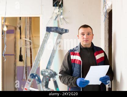 Professional electrician reads electrical wiring plan Stock Photo - Alamy