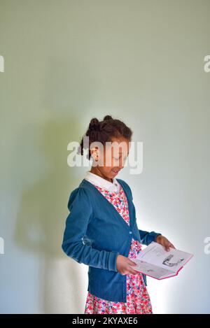 little girl standing up reading a book for school Stock Photo - Alamy