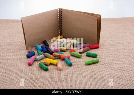 Notebook beside some colorful crayons Stock Photo - Alamy