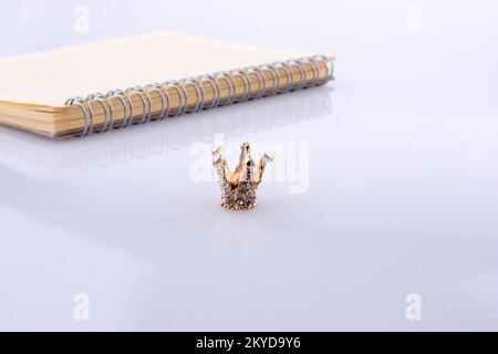 Crown with a notebook on a white background Stock Photo - Alamy