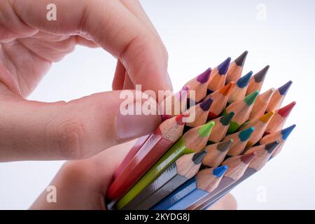 Hand holding color pencils on a white background Stock Photo - Alamy