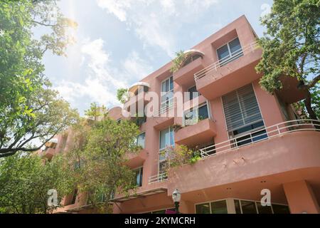 Building with painted peach wall and balconies facing the trees at the ...