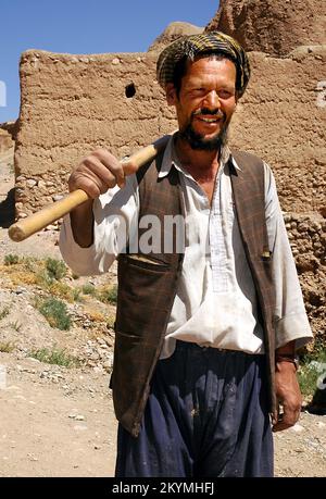 Bamyan (Bamiyan) / Central Afghanistan: A man carries a shovel as he ...