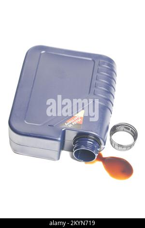 open engine oil bottle with a puddle of engine oil isolated on white ...