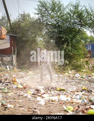 Man sweeping the trash with broom and polyhthene big garbage area, Man ...