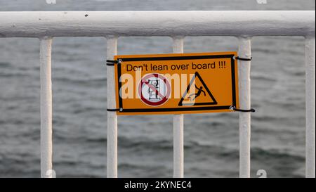 Do Not Lean Over warning sign on railing of cruise ship Stock Photo - Alamy