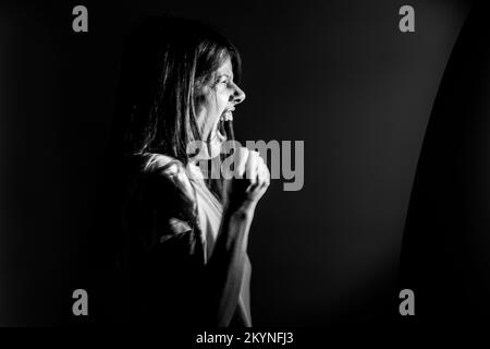 The girl screams in the dark from anger and rage, pain and scream Stock ...