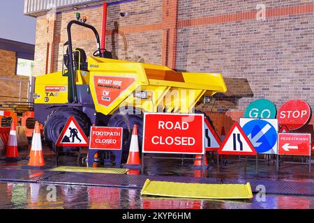 A 9 tonne forward tipping dump truck and road signs at a plant hire ...