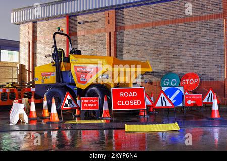A 9 tonne forward tipping dump truck and road signs at a plant hire ...