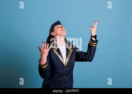 Prayer stewardess in aviation uniform begging, praying to gods, looking ...