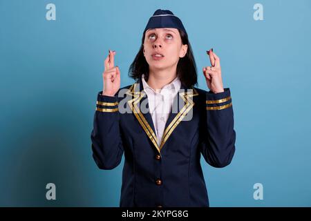 Prayer stewardess in aviation uniform begging, praying to gods, looking ...