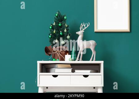 Small Christmas tree with toys, candle and glowing lights on table in ...