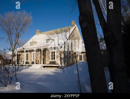 Old 1700s two story Canadiana style fieldstone home through trees in ...