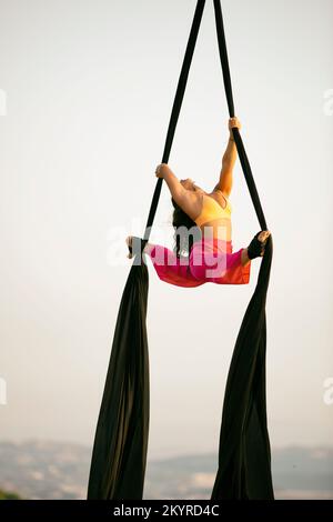 Young female aerialist performing on silk outdoors Stock Photo - Alamy