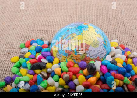 Model globe placed amid colorful pebbles Stock Photo - Alamy
