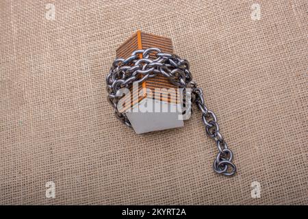 Chain wrapped around a model house on a brown background Stock Photo ...